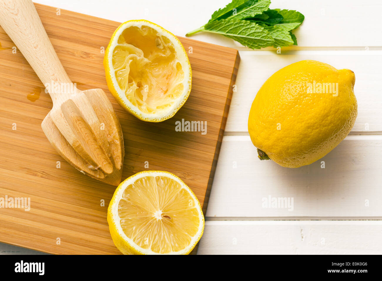 squeezed lemon fruit and citrus reamer on kitchen table Stock Photo - Alamy