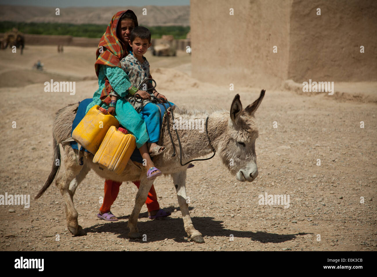 Villagers pass by an over watch position for Afghan National Army ...