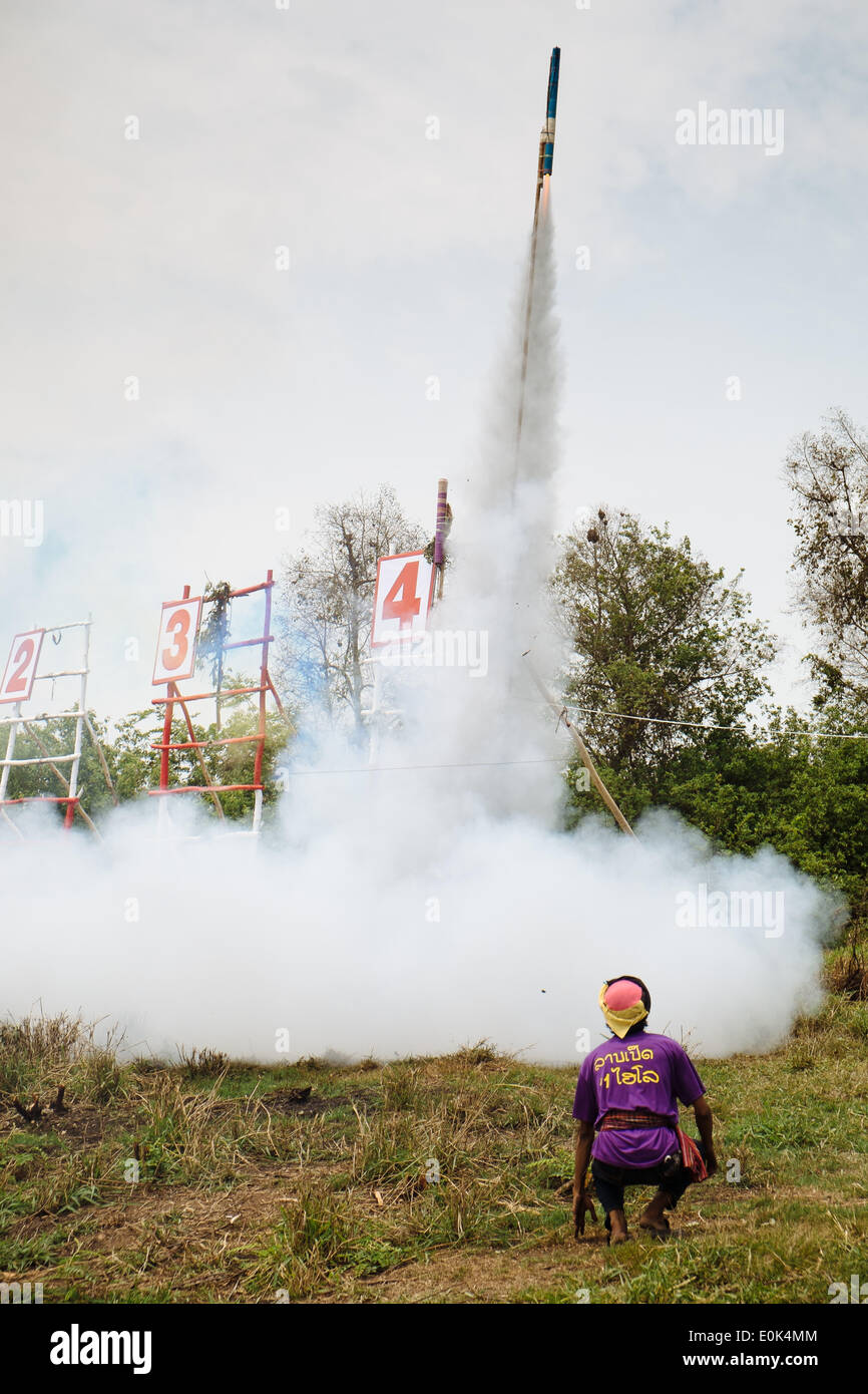 Yasothon, Thailand. 11th May, 2014. A man looks up as a rocket is fired ...