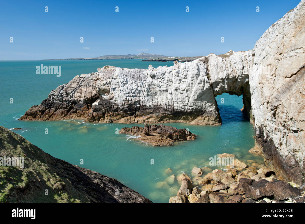 Bwa Gwyn white natural rock sea arch on coast, near Rhoscolyn, Anglesey ...