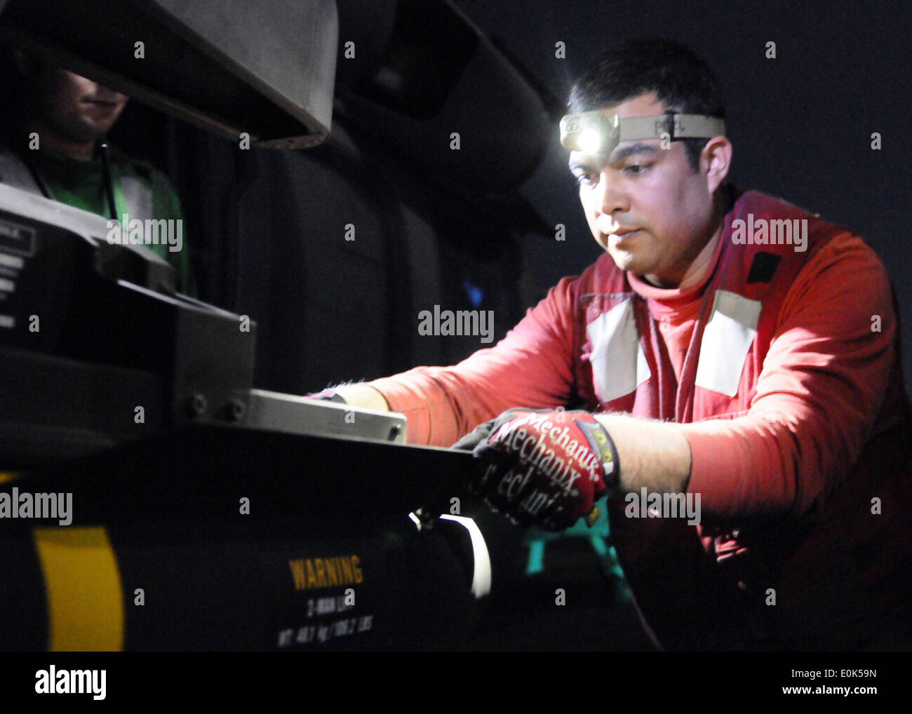 Petty Officer 1st Class Joseph Federico, aviation ordnanceman, loads a ...