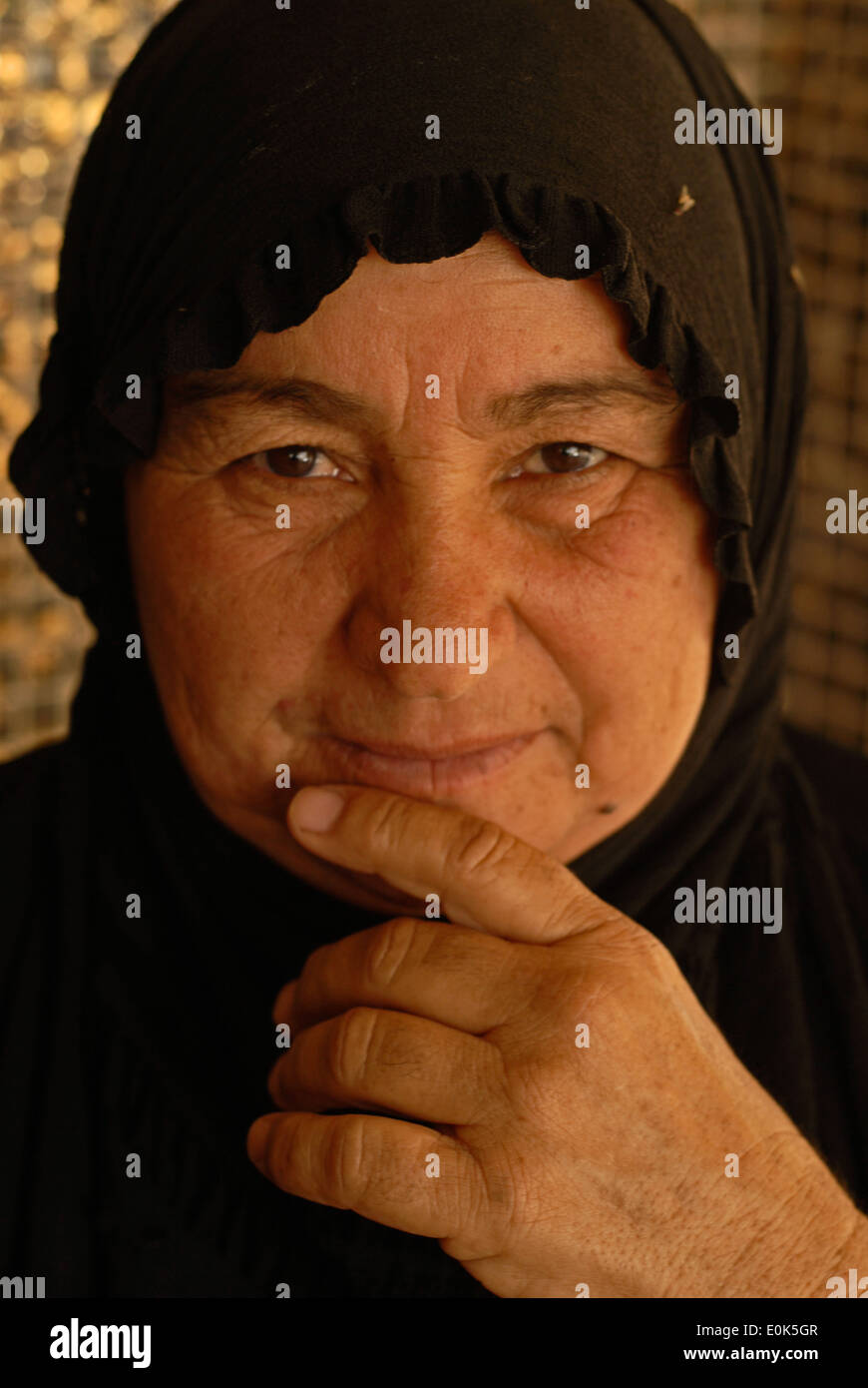 A local resident stares intently into the camera while U.S. Soldiers ...