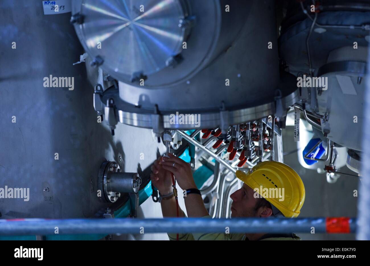 Technicians work on a circular plasma vessel at the research reactor ...
