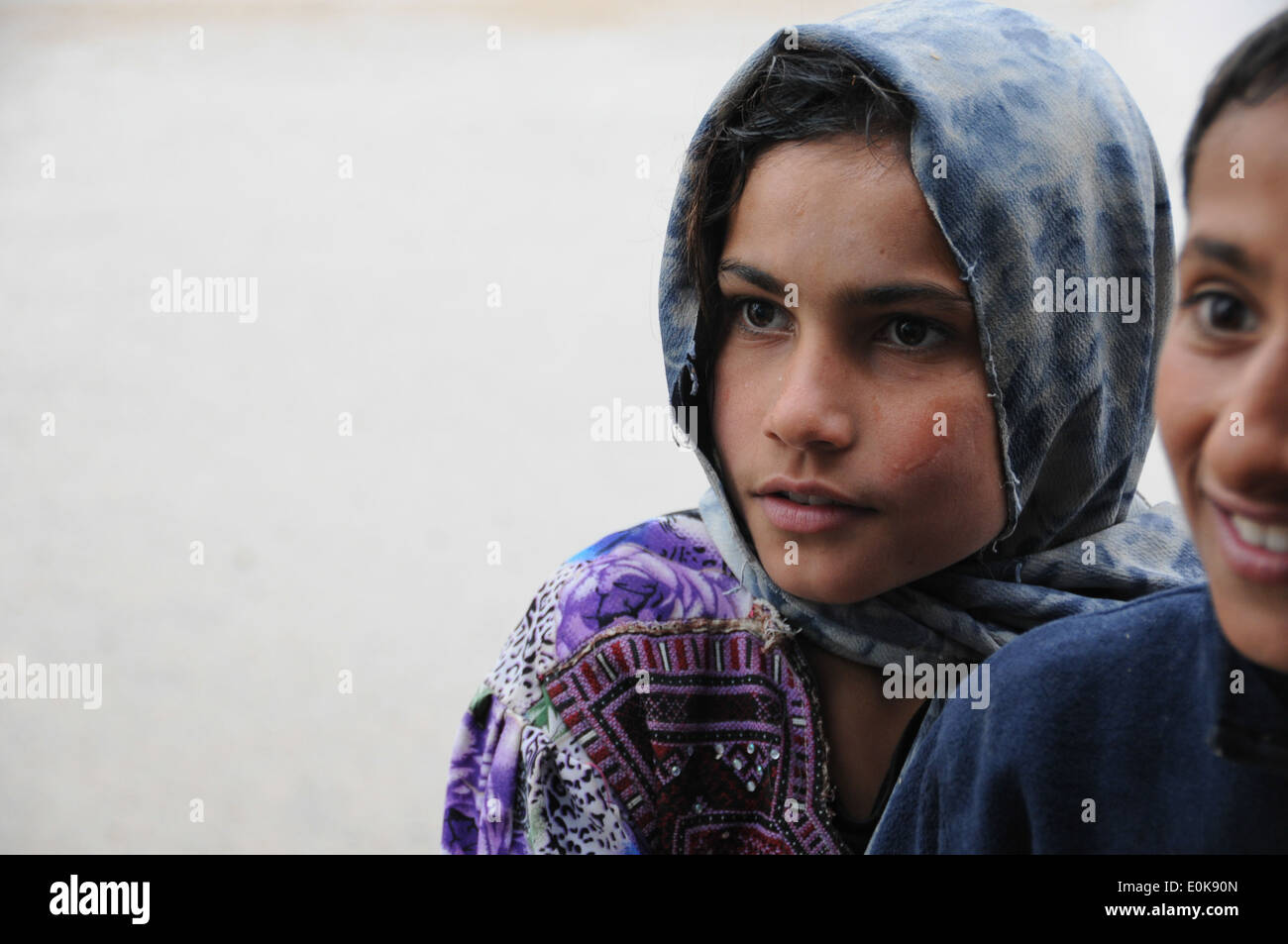 A young Farahi girl looks on as her brother and friends talk with ...