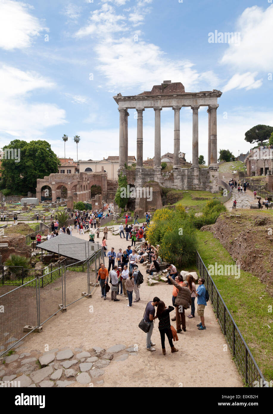 Tourists visiting the Roman Forum looking at the Temple of Saturn, Rome ...