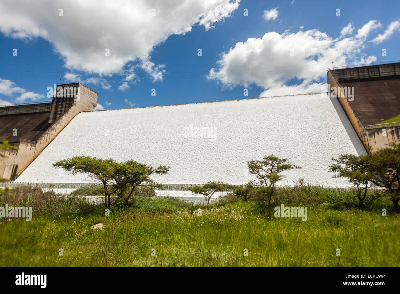 Dam Wall structure with rain water flowing over top into river valley ...