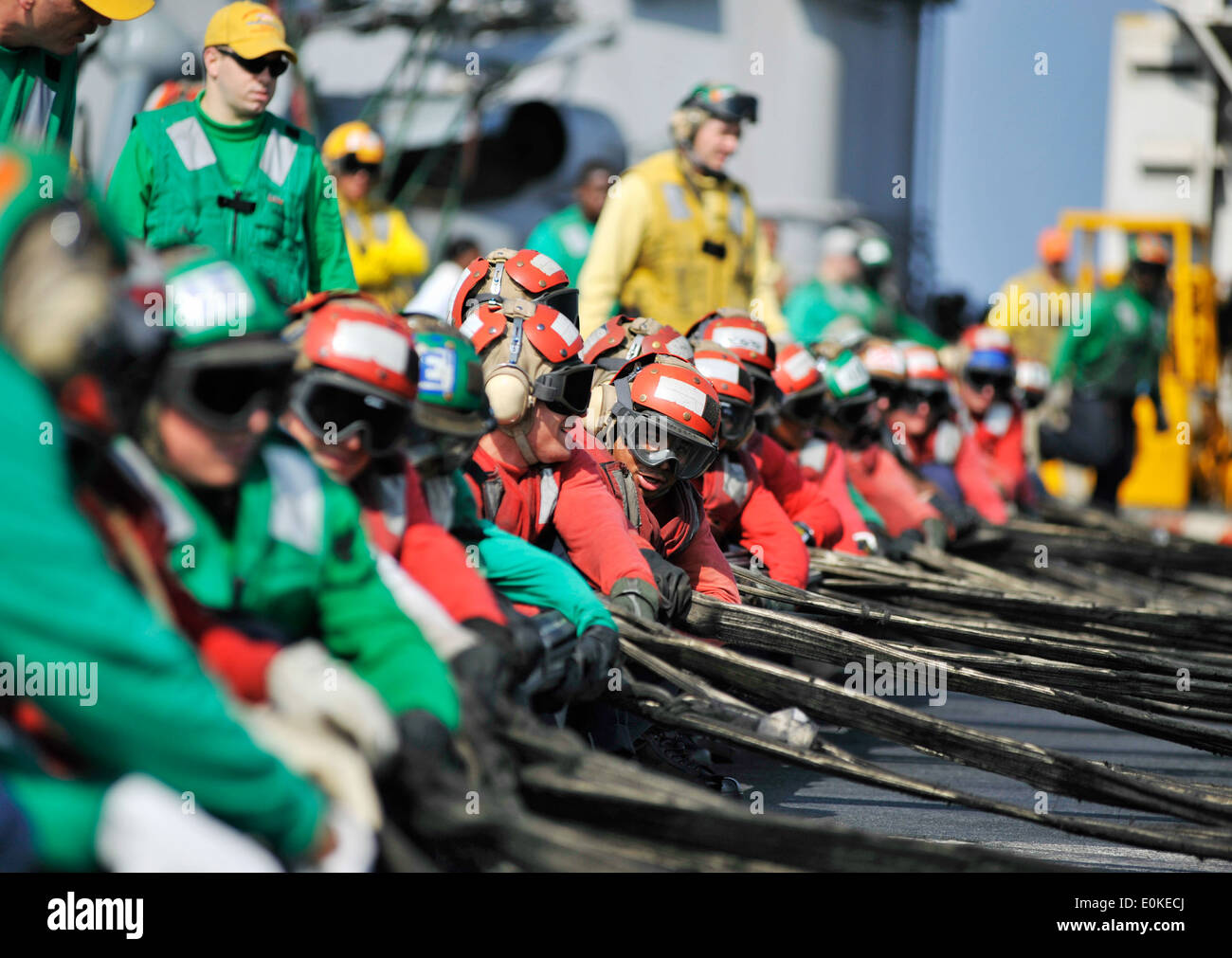 Sailors and Marines heave in a barricade net during a crash barricade ...