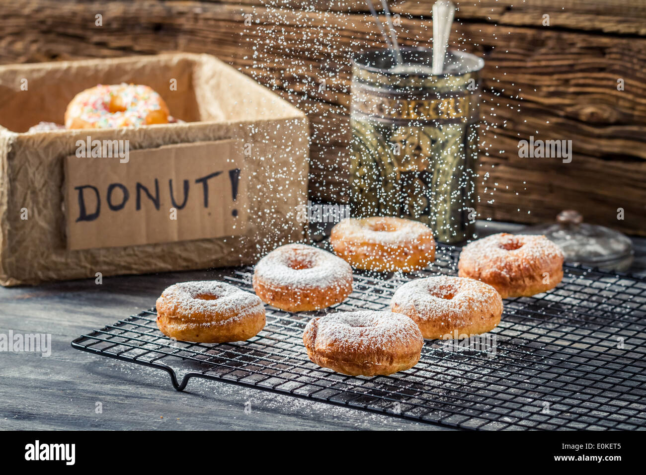 Icing sugar falling on fresh donuts Stock Photo - Alamy