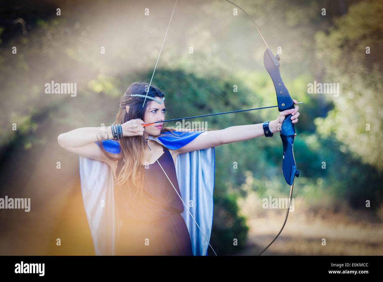 elven wood princess shooting bow and arrow Stock Photo - Alamy