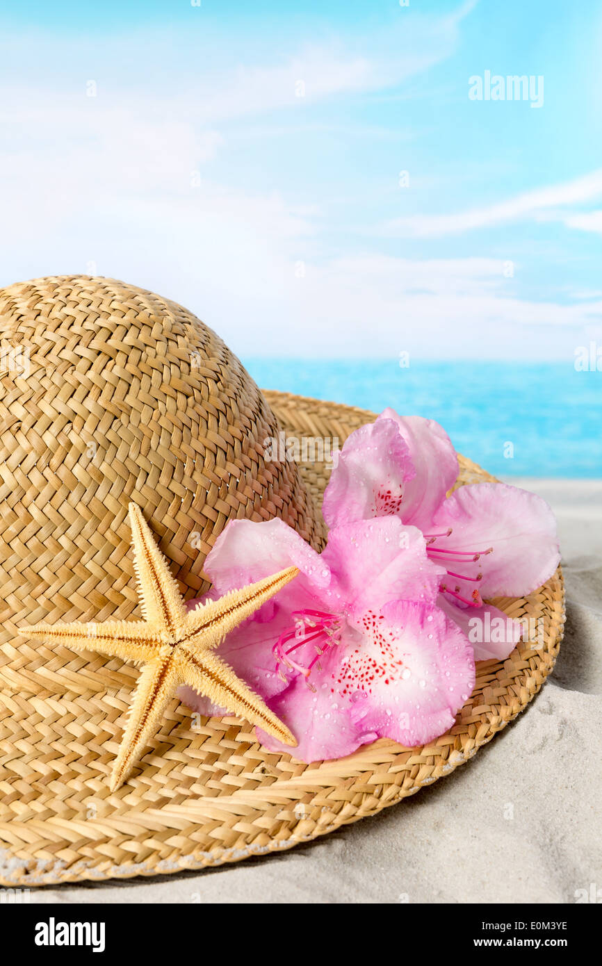 Sun hat with pink flowers and starfish on the beach Stock Photo - Alamy