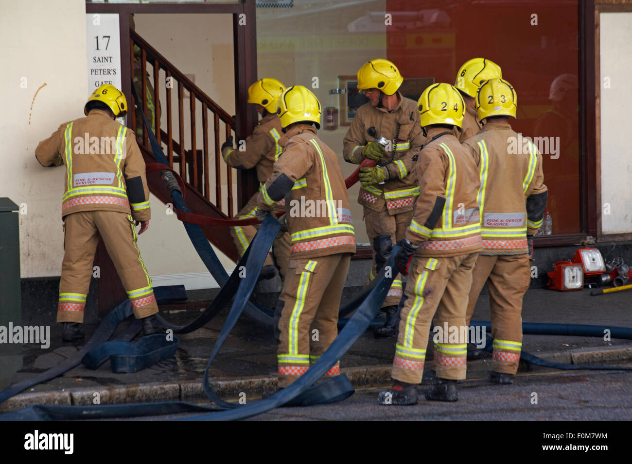 firemen and hoses at scene of fire on top floor of students flats ...