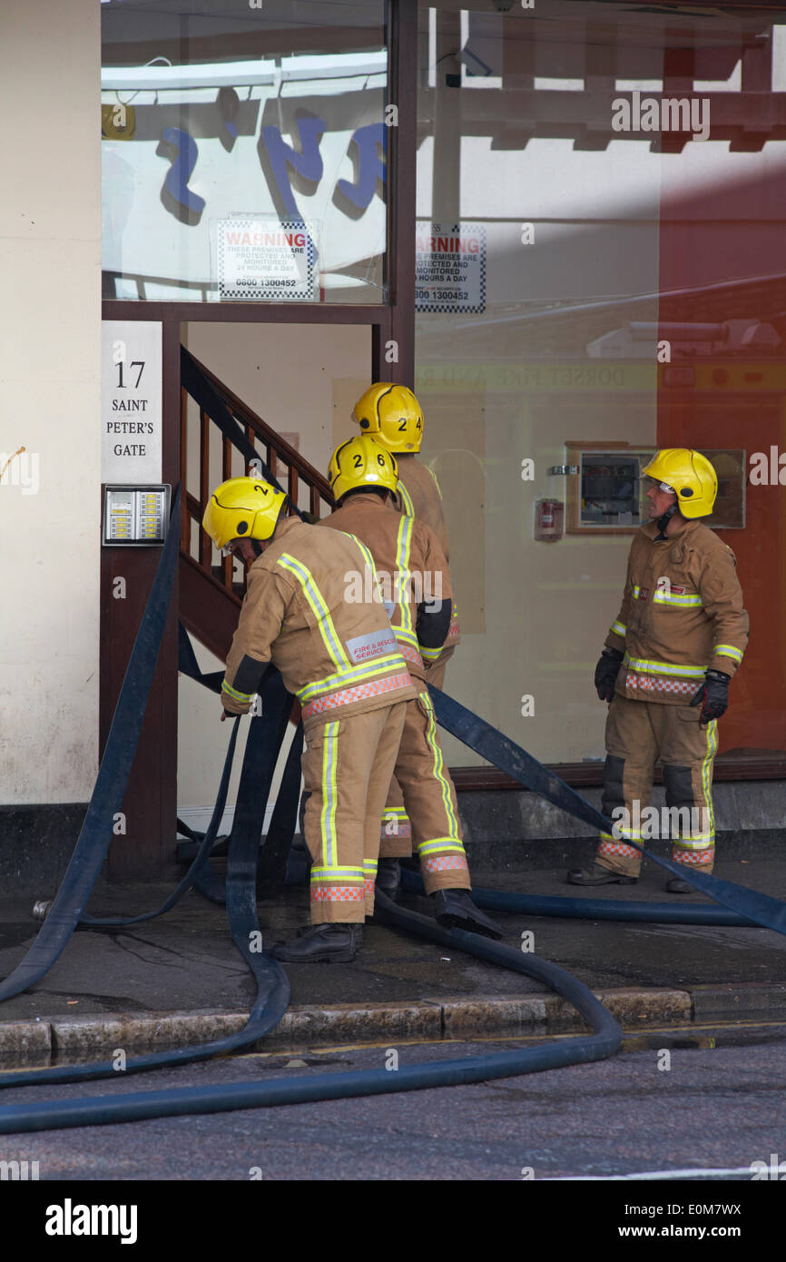 firemen and hoses at scene of fire on top floor of students flats ...
