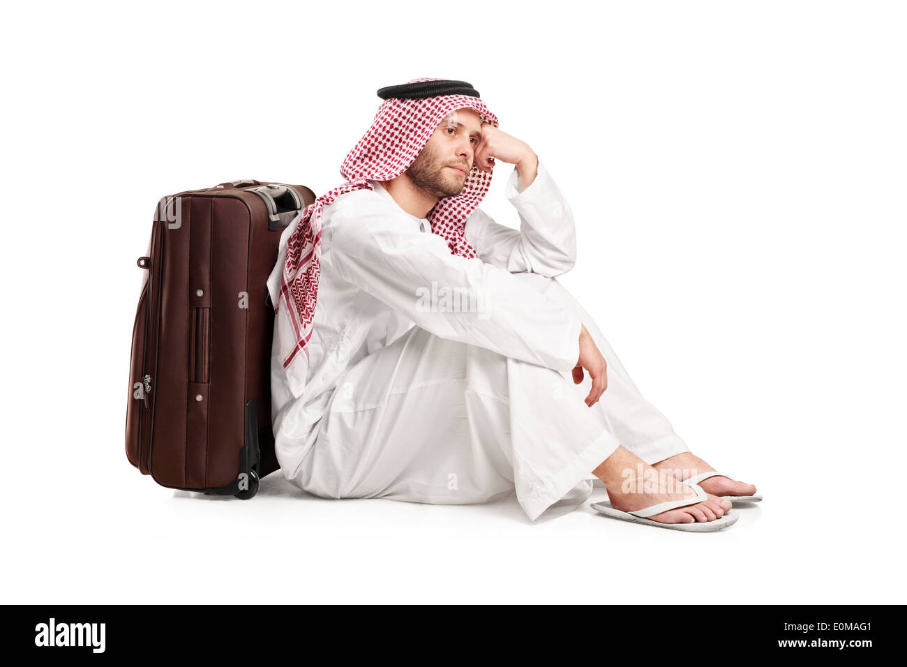 Sad Arabic man sitting on the floor with a bag behind his back Stock ...