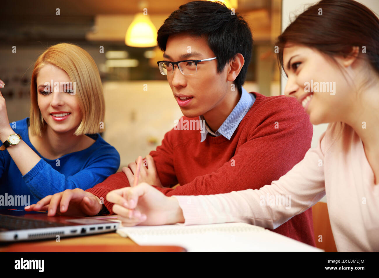 Happy friends using laptop together Stock Photo - Alamy