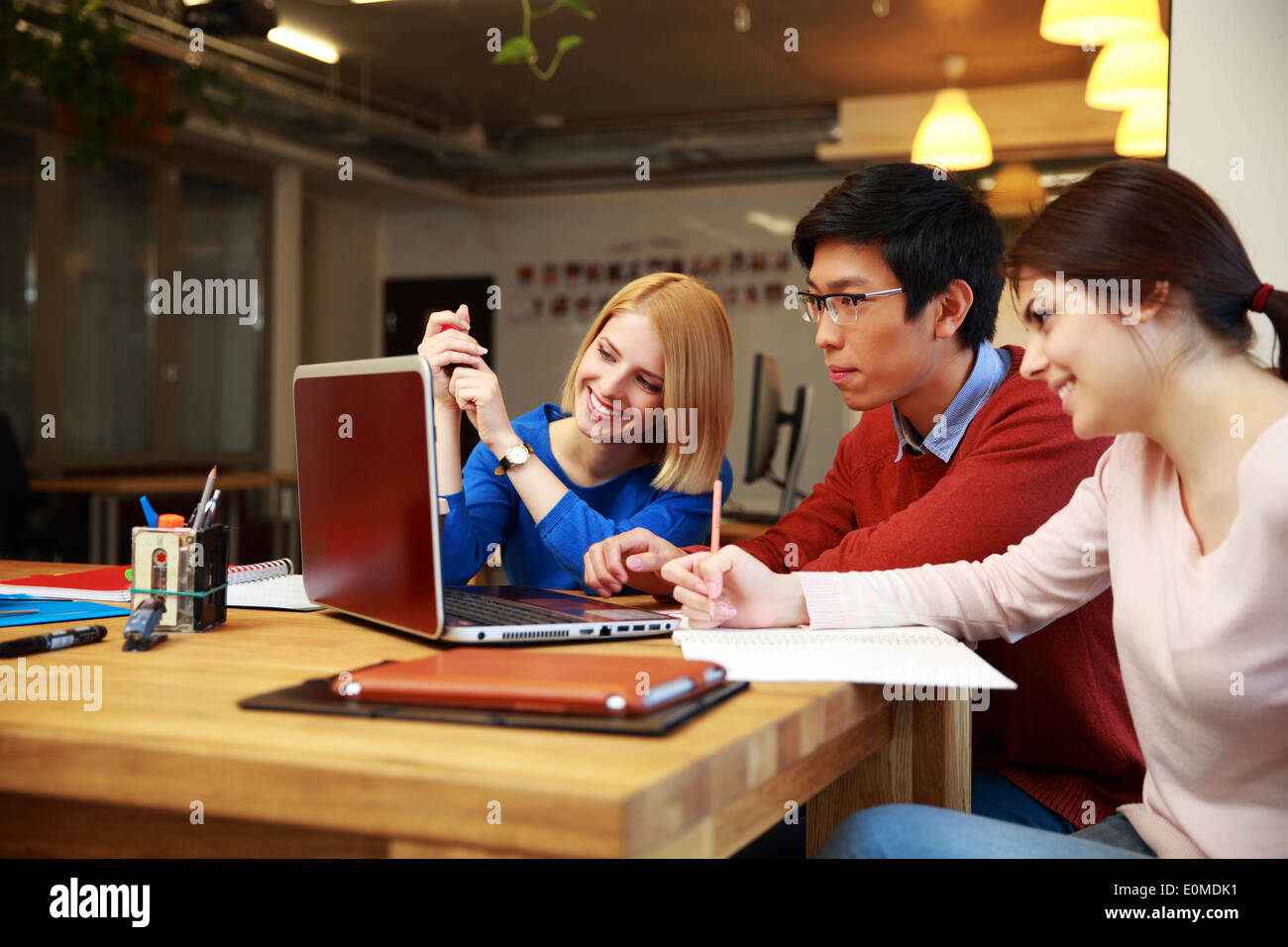Happy students doing homework with laptop together Stock Photo - Alamy