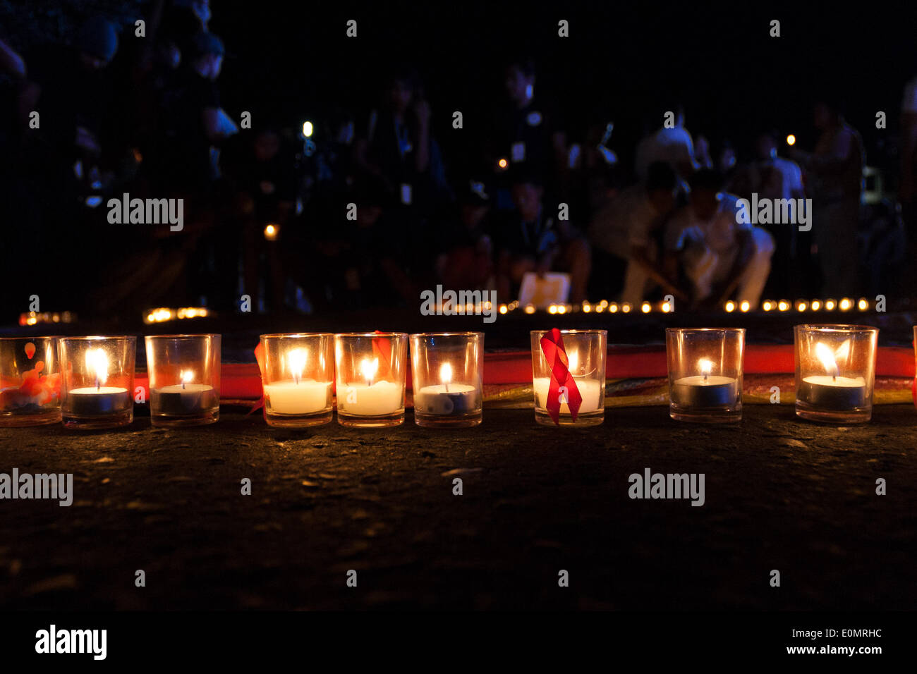 MANILA, PHILIPPINES - MAY 16: Lit candles with red ribbons were placed ...