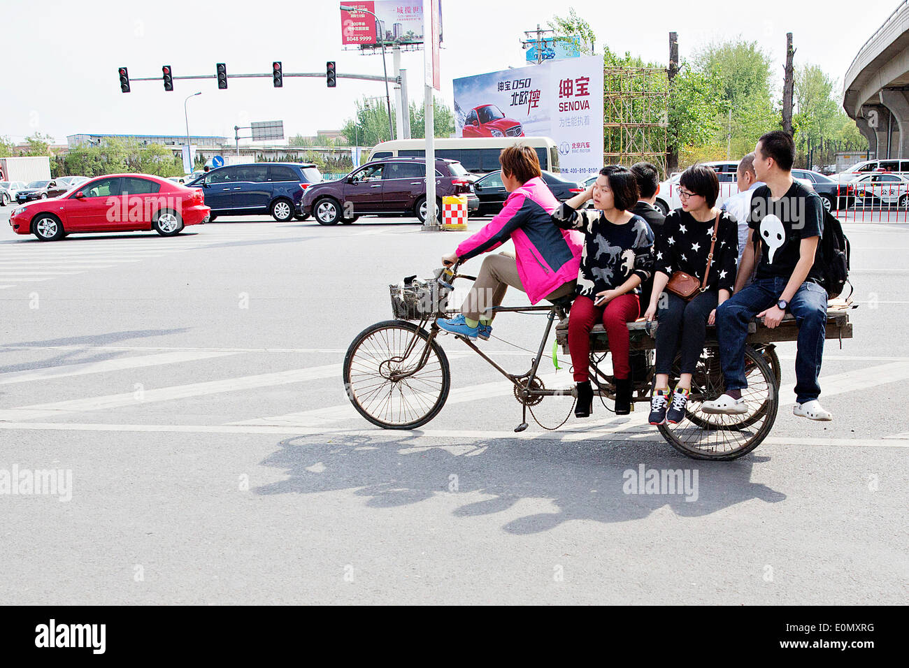 A Chinese woman drives motorized rickshaw loaded with customers through ...