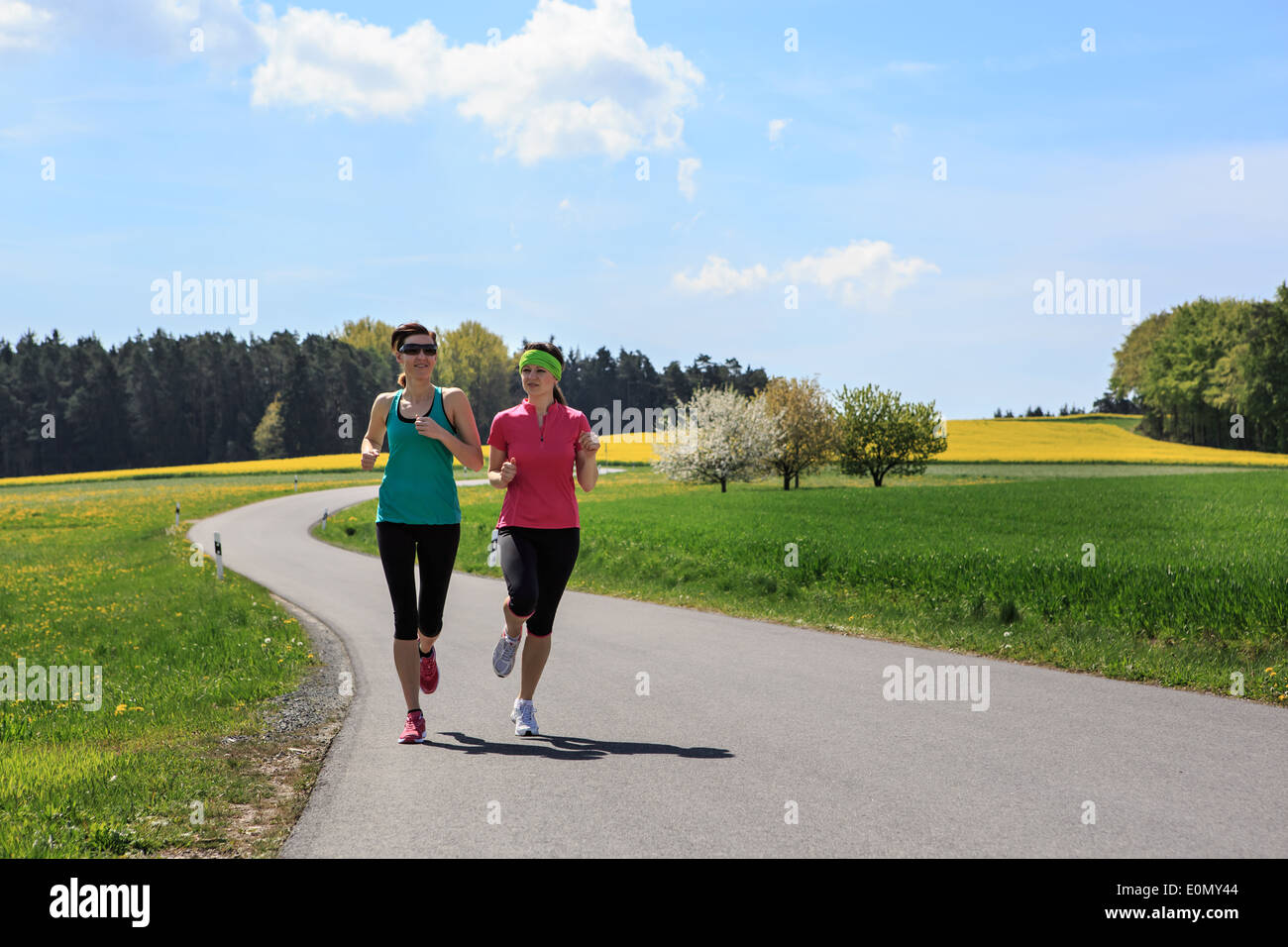 two women jogging through fields at the springtime Stock Photo - Alamy