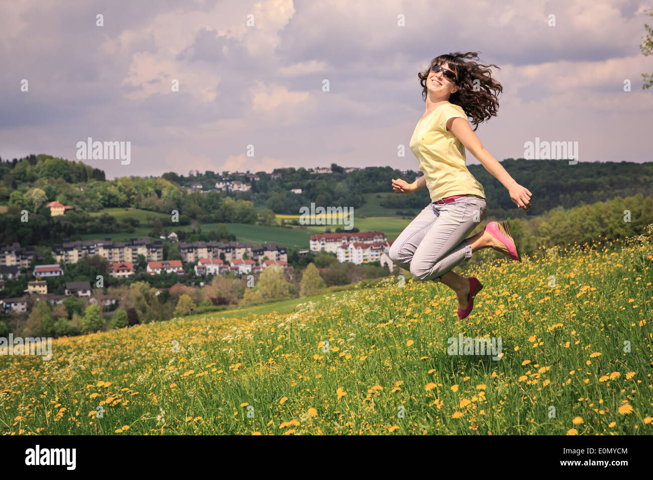 a young jumping woman in front of rural landscape Stock Photo - Alamy