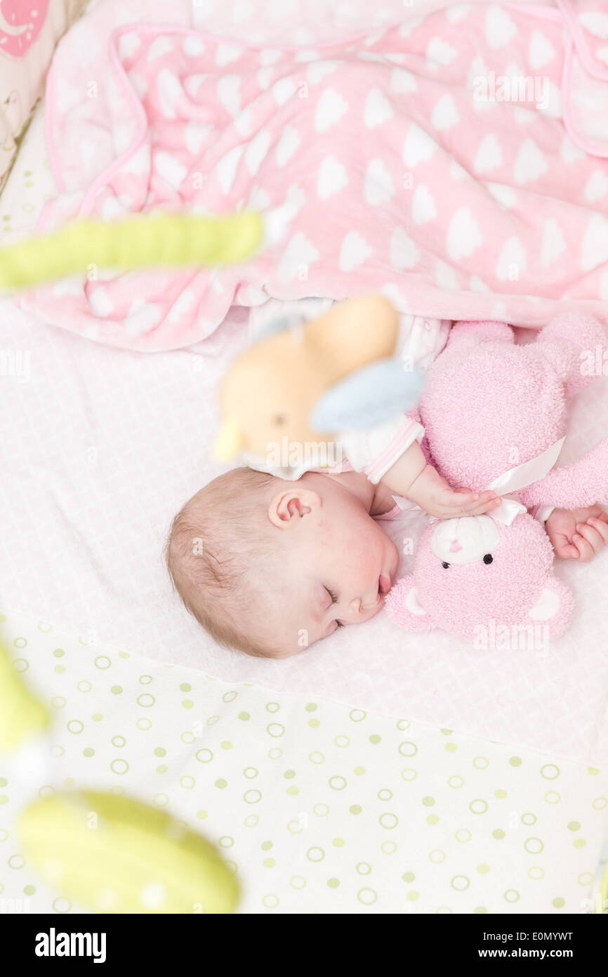 Cute baby girl sleeping in her crib Stock Photo - Alamy