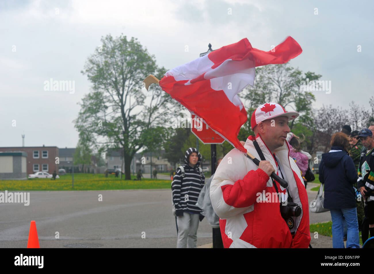 A man in a Canadian tracksuit holds a Canadian flag Stock Photo - Alamy