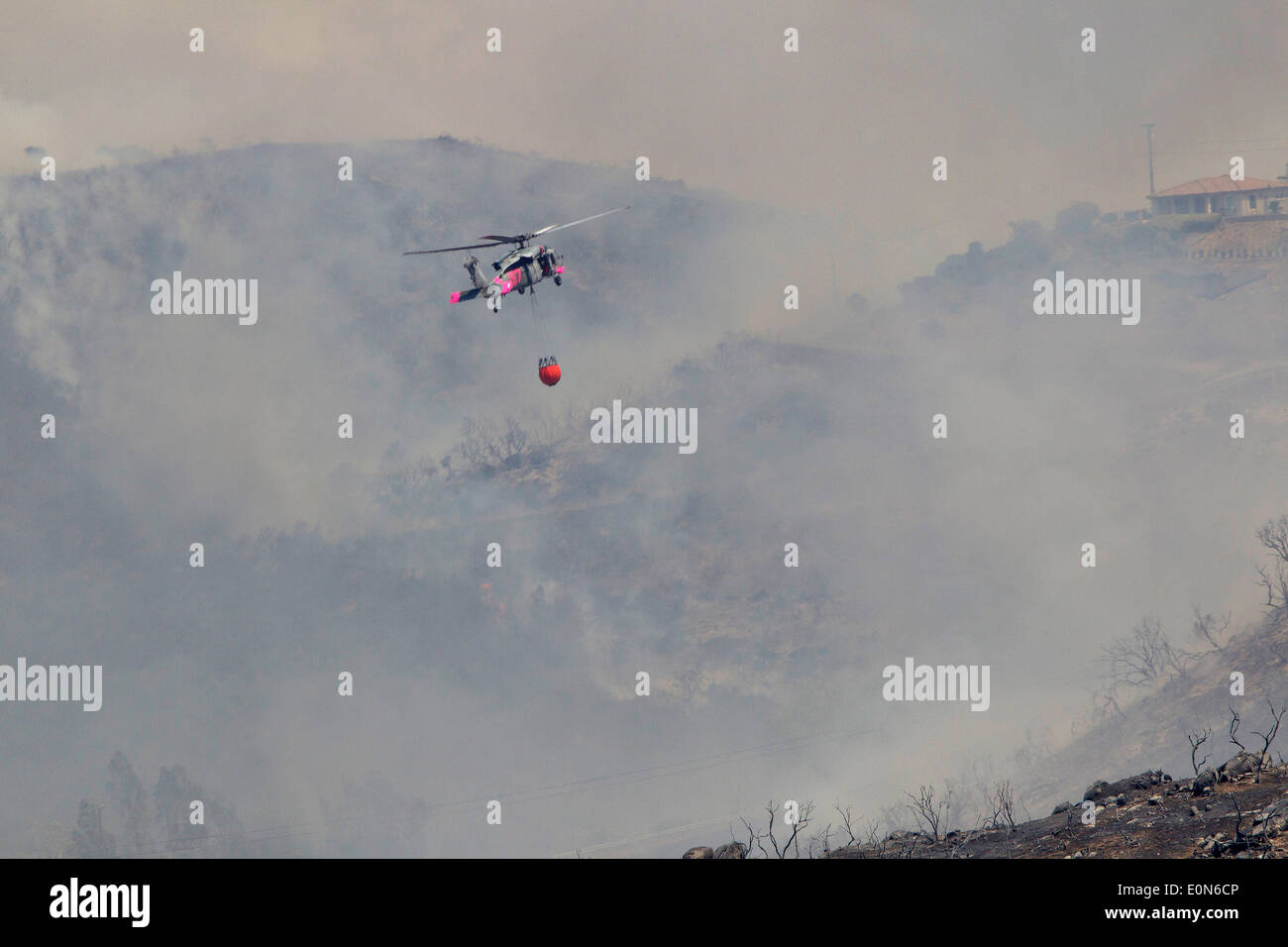 A US Marine Corps HH-60H Sea Hawk helicopter carries a monsoon bucket ...
