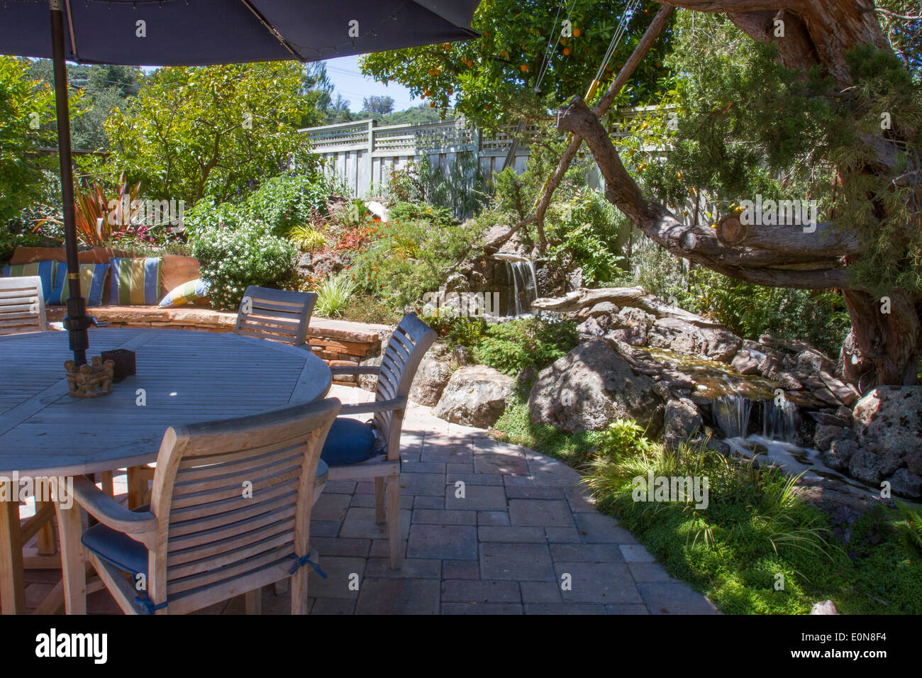 Water feature stream flowing next to a dining patio in a beautiful ...