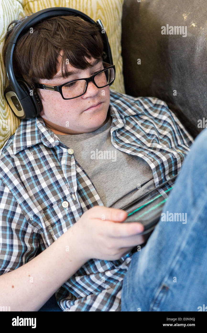 Teenage boy playing with his computer gadgets at leisure time Stock ...