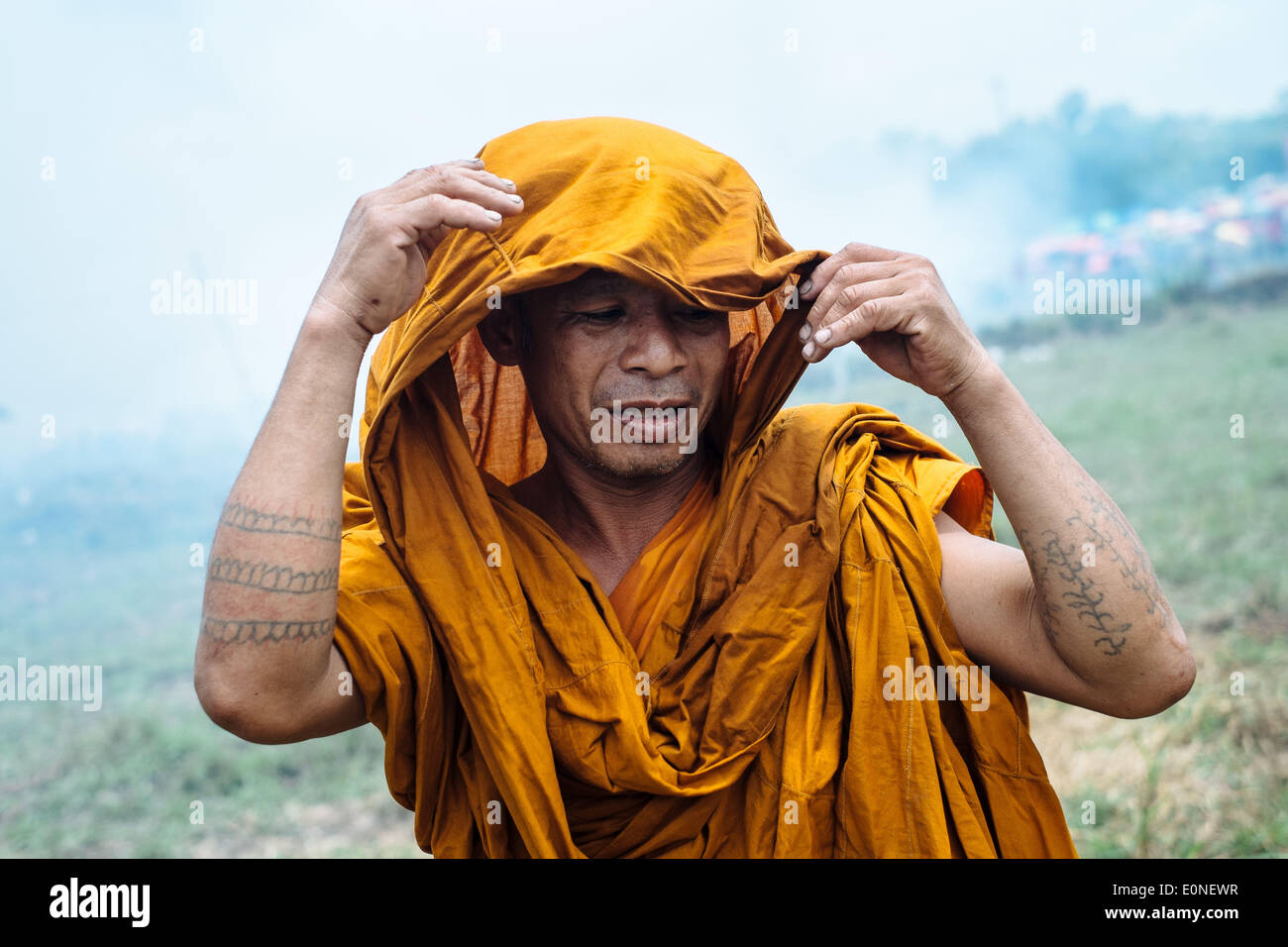 Yasothon, Thailand. 11th May, 2014. A Buddhist monk looks up as a ...