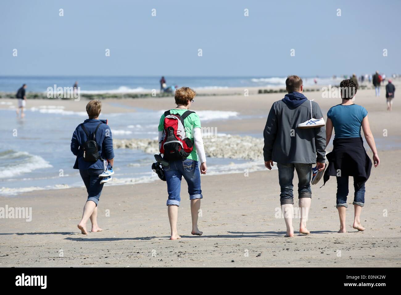 People walk in the sun at the beach on the isle of Sylt in Westerland ...