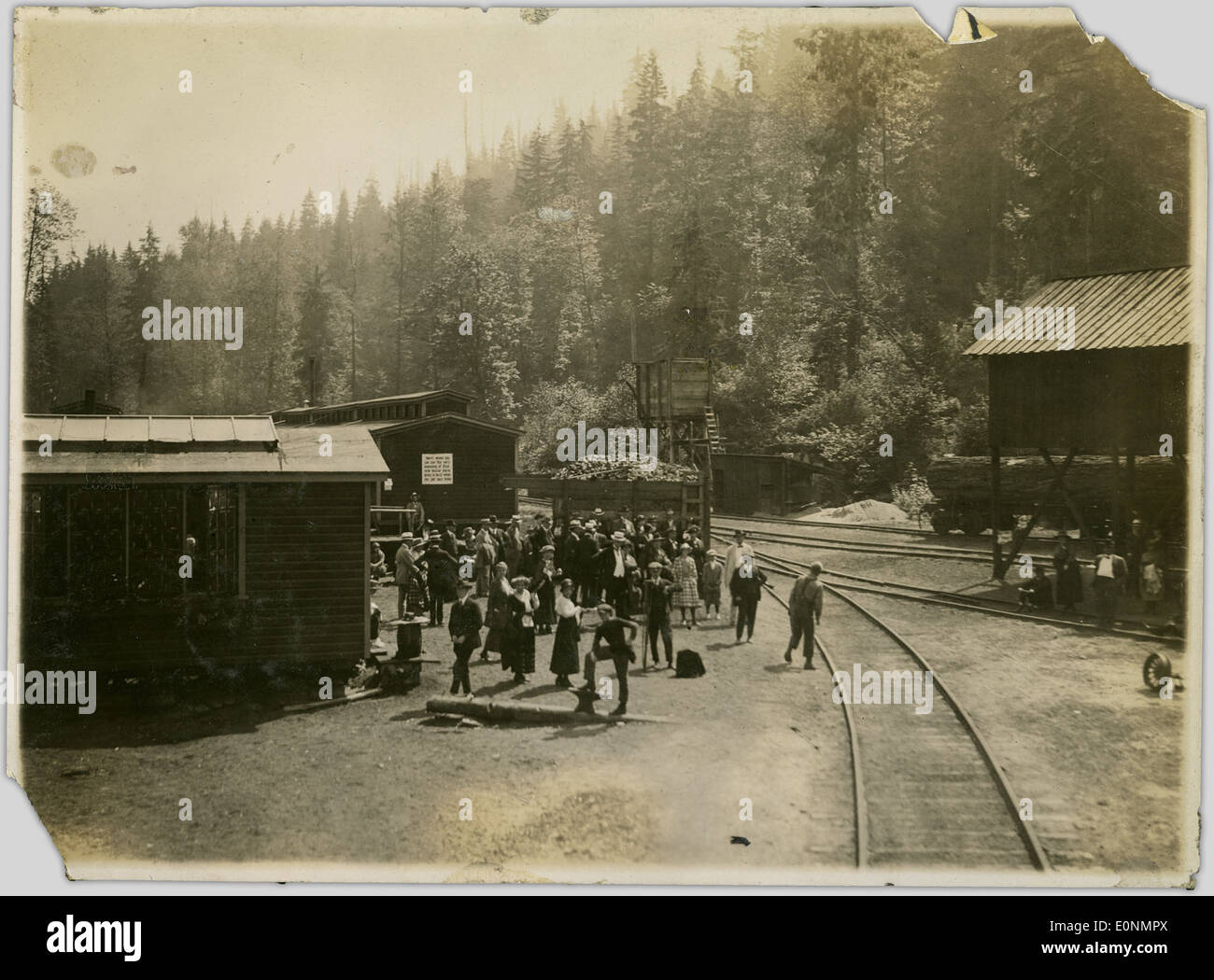 This photograph captures a tour of a logging camp, showcasing the ...