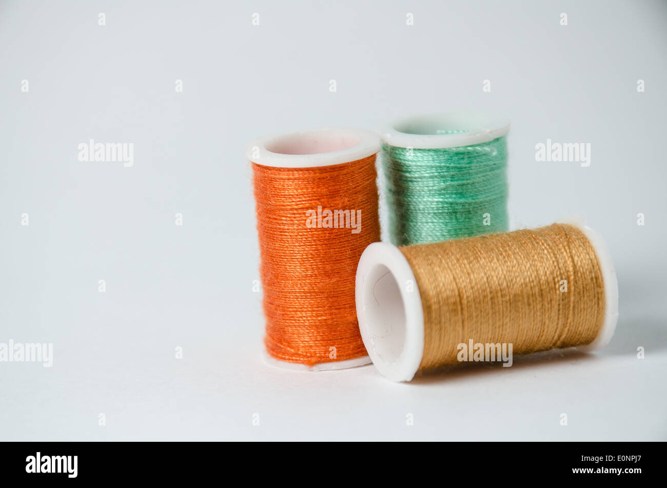 Three thread rolls against white background Stock Photo - Alamy