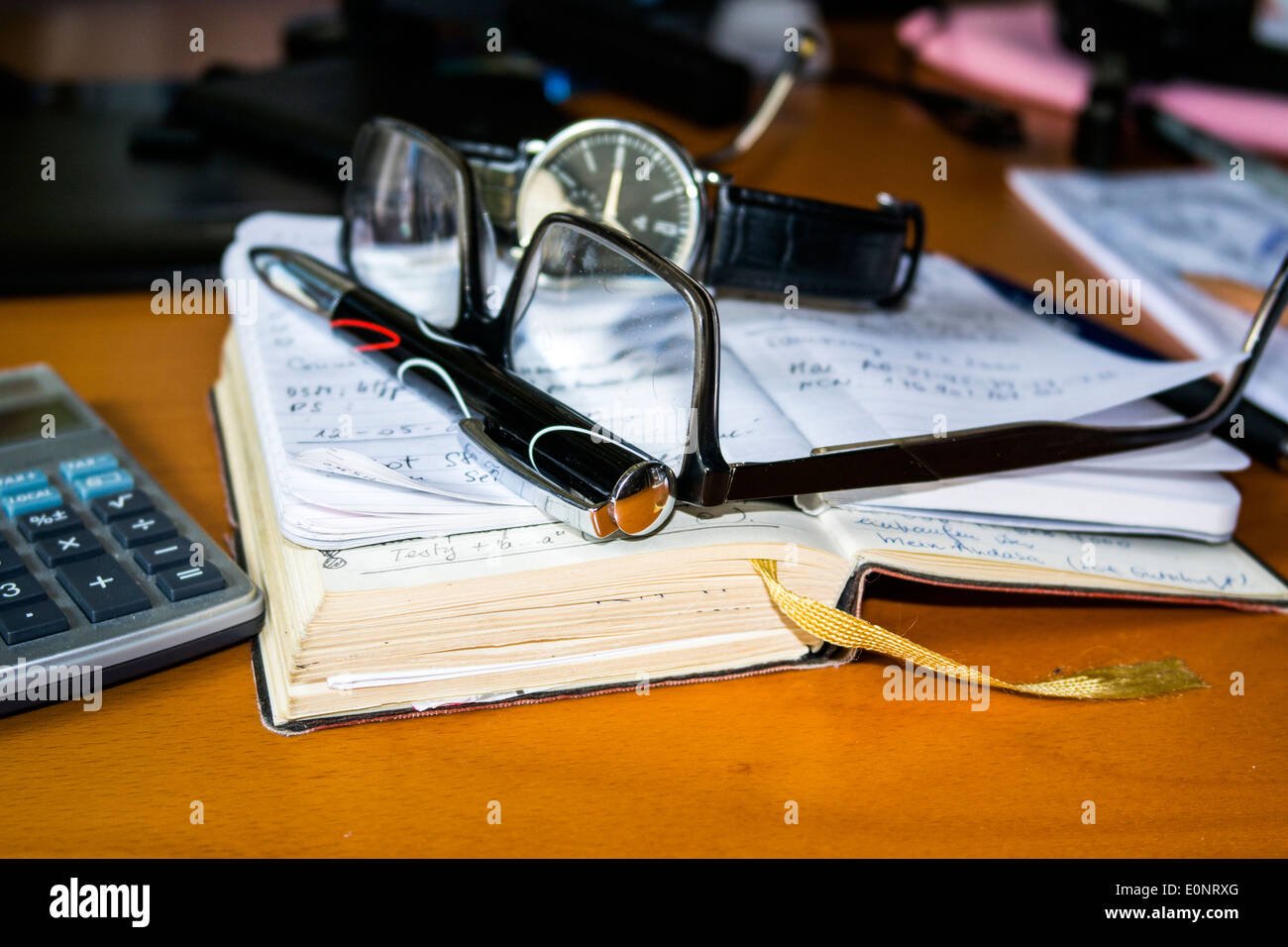 Diary book with glasses, watch, pen and calculator on my desk Stock ...