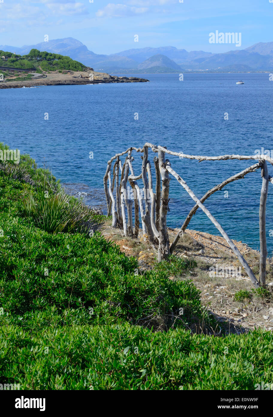 Vertical landscape with wooden fence, blue ocean and mountains over ...