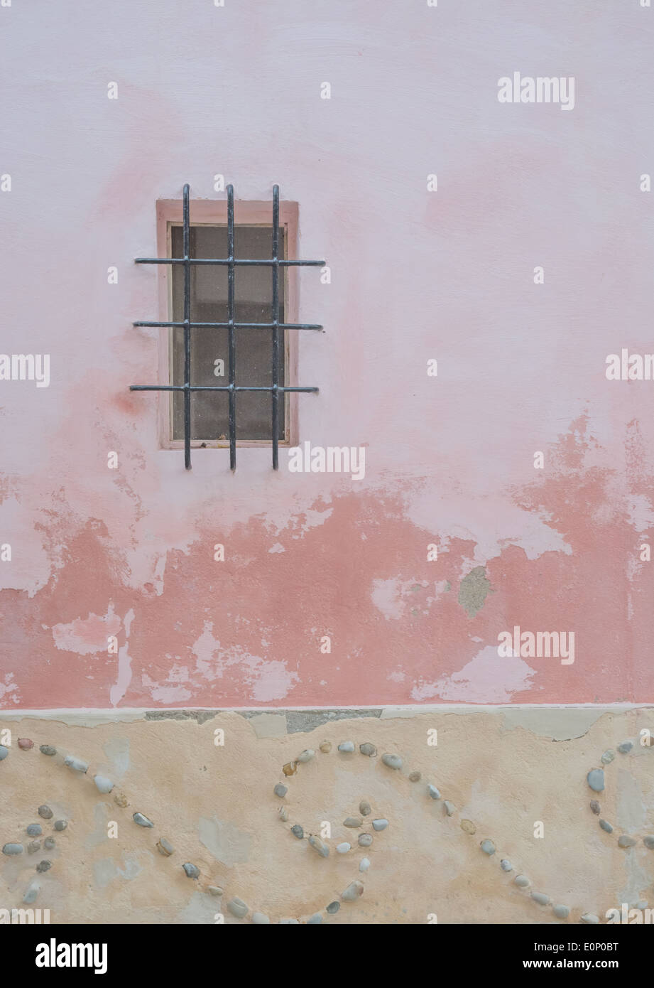 Pink facade, black iron window and decorative friese with little ...