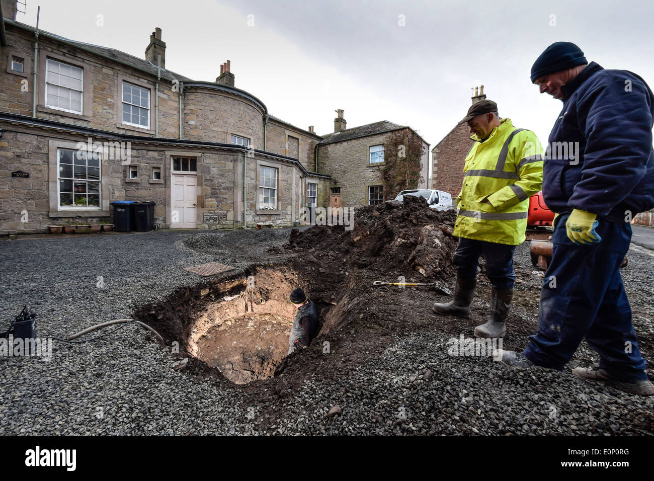 Builders inspect a hidden underground structure revealed by a void ...