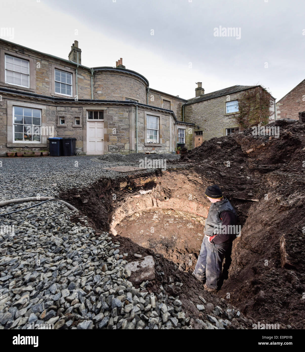 Builder inspects a hidden underground structure revealed by a void ...