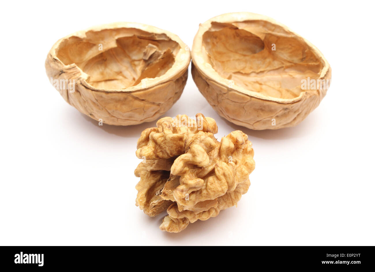 Closeup of brown walnut without shell and nutshells in background ...