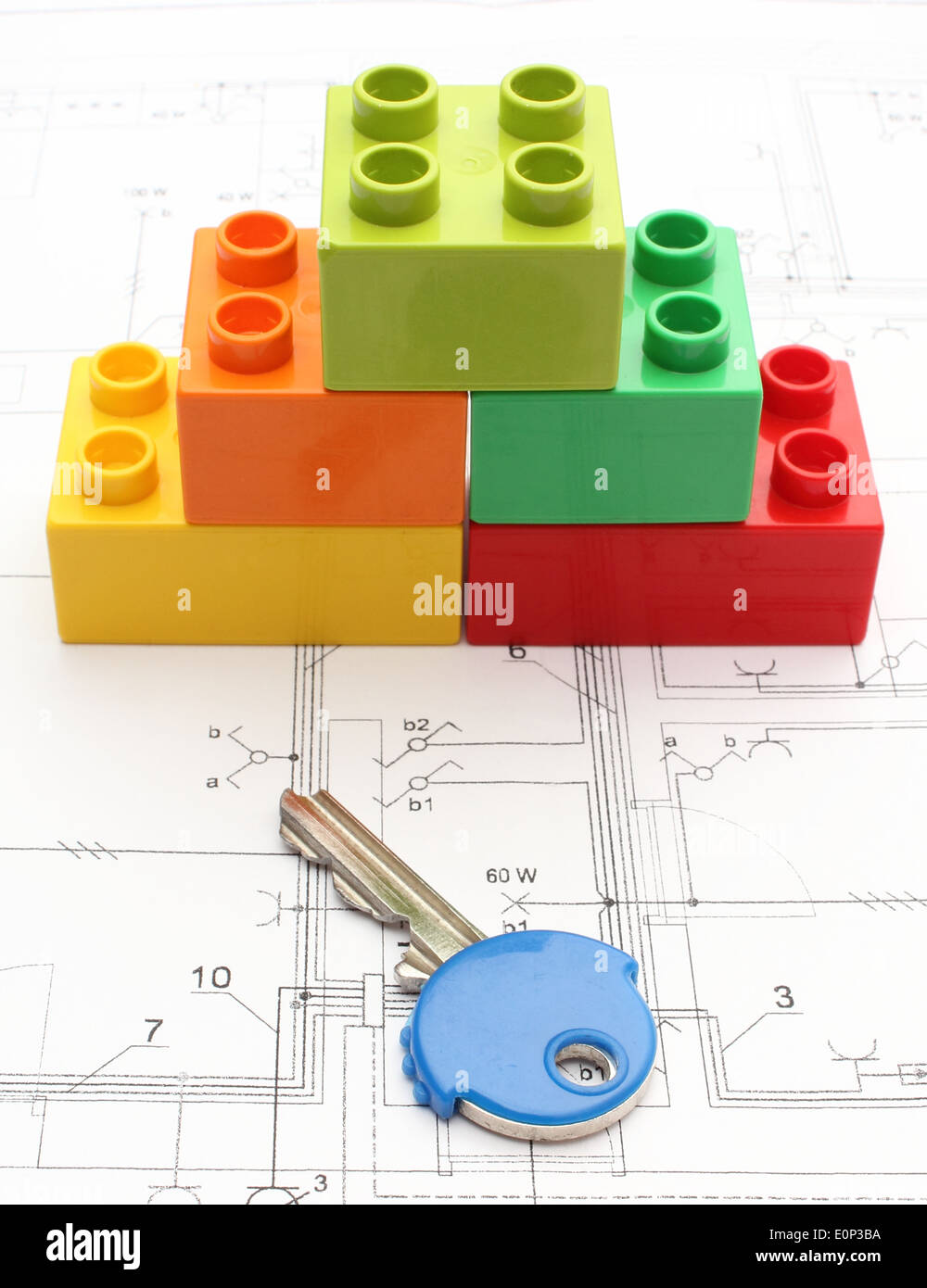 Colorful building blocks and key lying on construction drawing of house ...