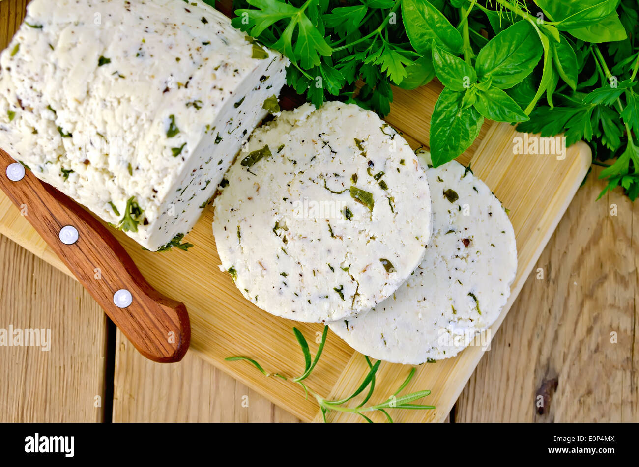 Homemade cheese with herbs and spices, cut into slices, knife, parsley ...