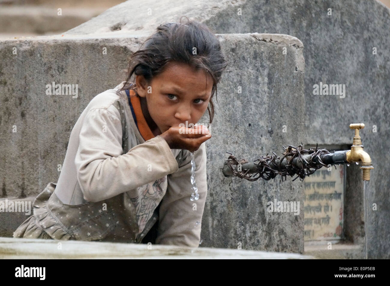 Young girl is drinking spring water at public faucet Stock Photo - Alamy