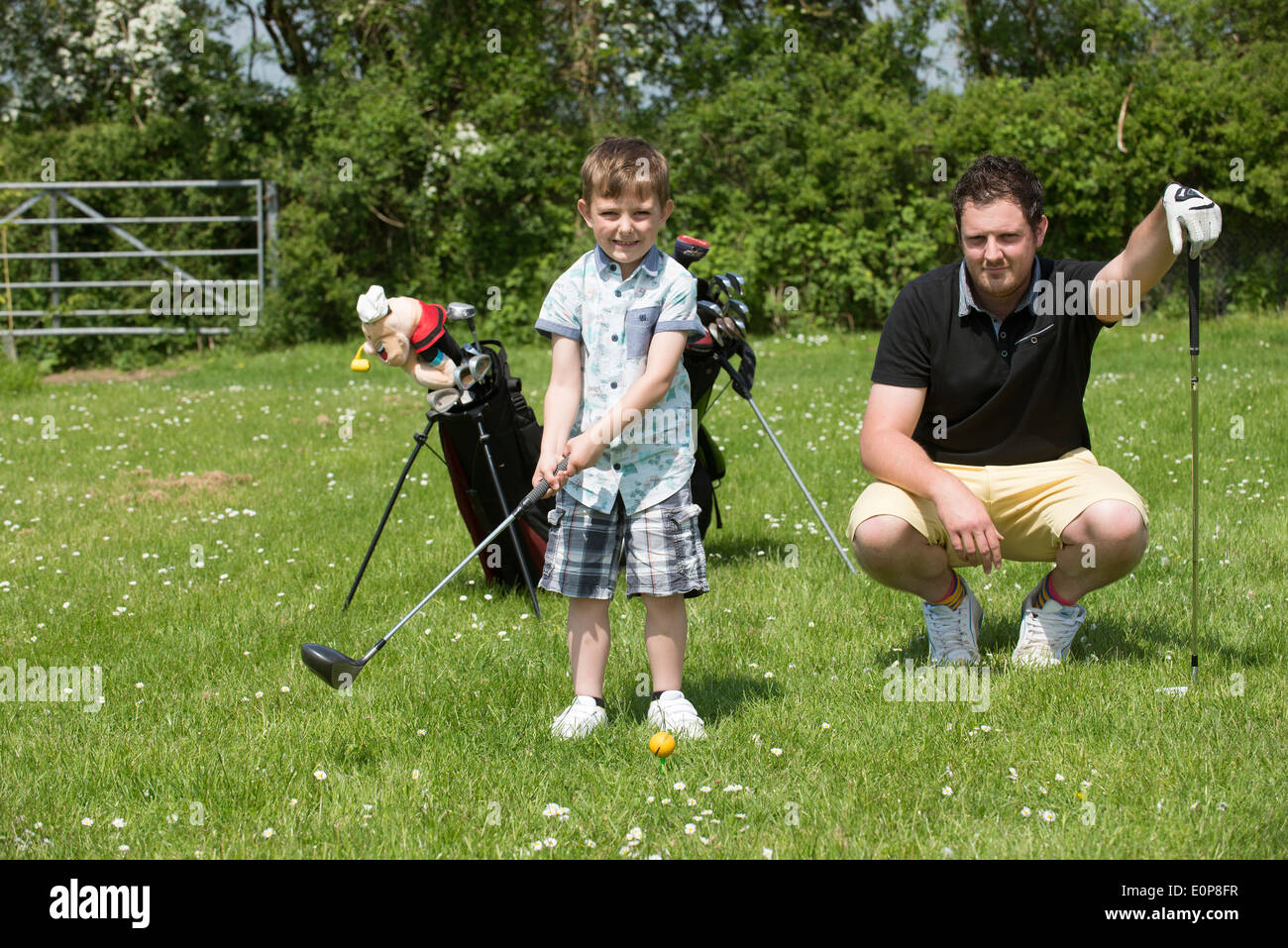 Five year old boy taking golf lesson with his father Hampshire England ...