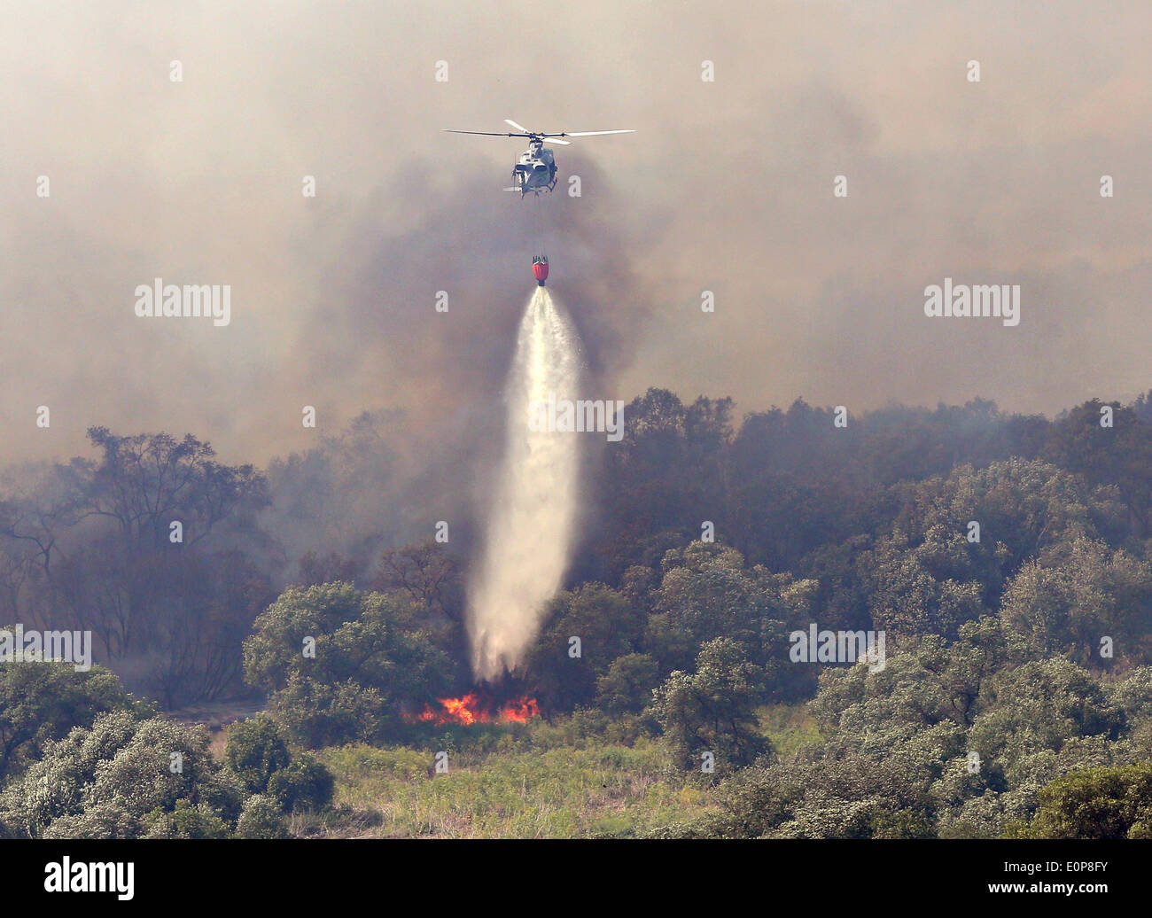 A US Marine Corps helicopter drops water from a bambi bucket to help ...