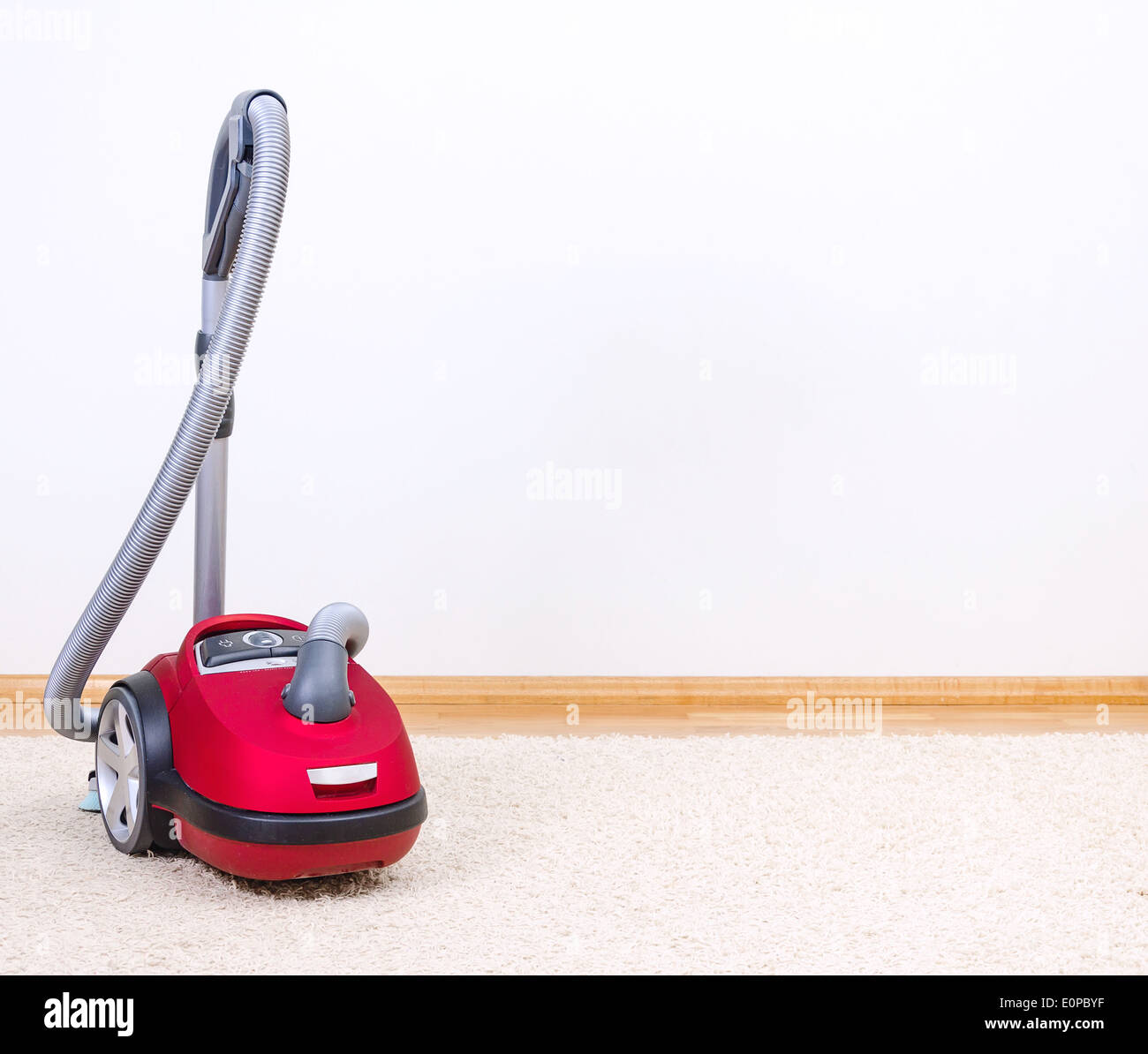 Red vacuum cleaner in empty room Stock Photo - Alamy