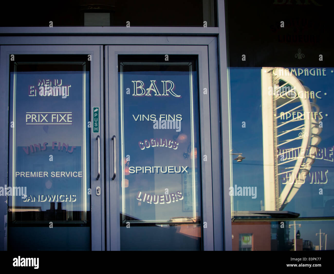 The spinnaker tower is reflected in a café window at Gunwharf Quays ...