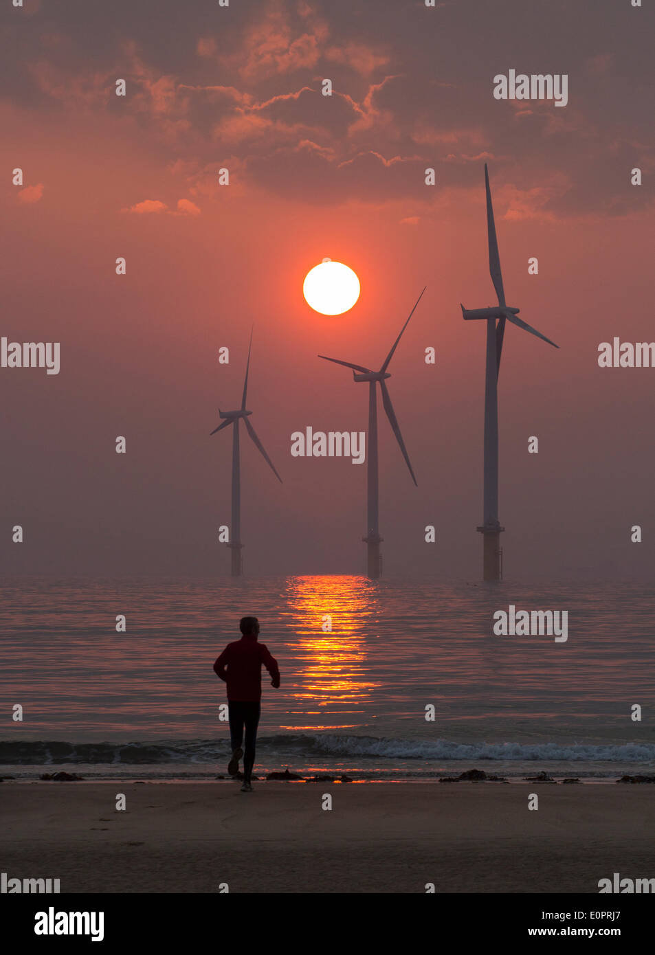 Redcar, England, UK. 19th May 2014. Jogger on Redcar beach at sunrise ...