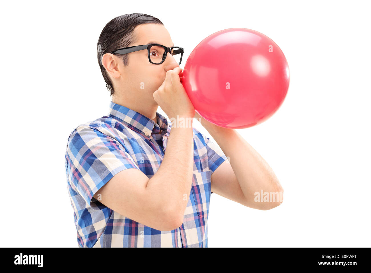 Young man blowing up a balloon Stock Photo - Alamy