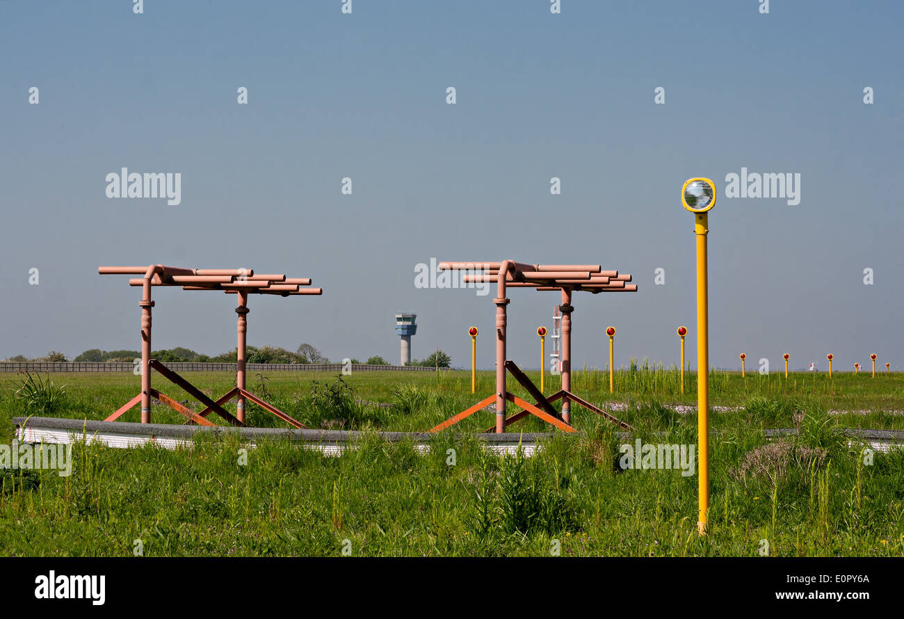 Airport landing lights with control tower in background Stock Photo - Alamy