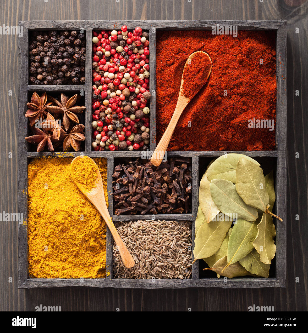 spices in box pink and black pepper, paprika powder, curry, bay leaf ...