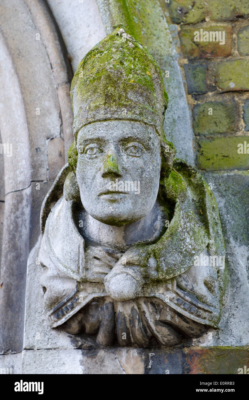 Carved stone head of a bishop on a medieval building in Winchester ...